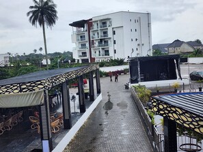 Um edifício com vários andares, varandas, área de estar coberta ao ar livre e palco.