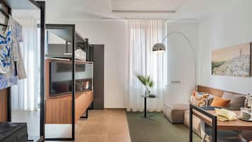 Uma sala de estar moderna com um sofá, uma mesa de jantar, um abajur e um quadro na parede.