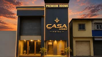 Um hotel com placa indicando 'CASA ANNEX HOTEL' e 'QUARTOS PREMIUM', sinalizando uma área para acomodações de alto padrão.