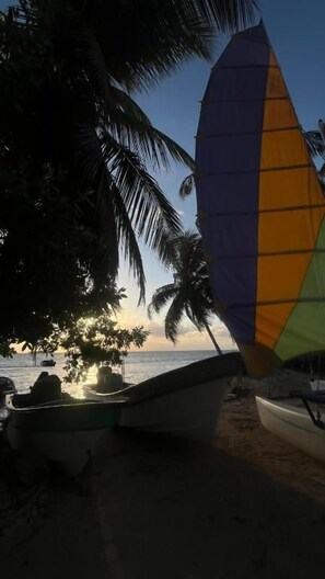 Uma praia com barcos e uma vela.