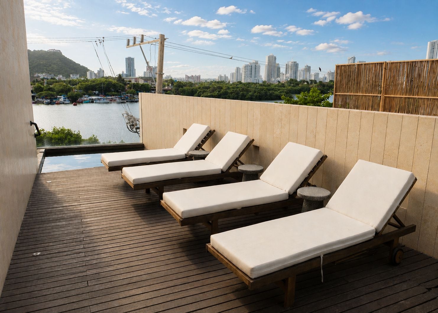Uma área de lounge no terraço, com piso de madeira e poltronas confortáveis com almofadas brancas.
