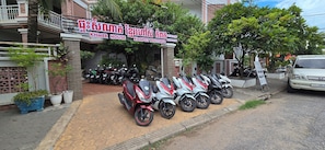 Um edifício com uma placa indicando 'KHMER HOUSE KAMPOUT BOUTIQUE' e uma fileira de motocicletas estacionadas em frente.
