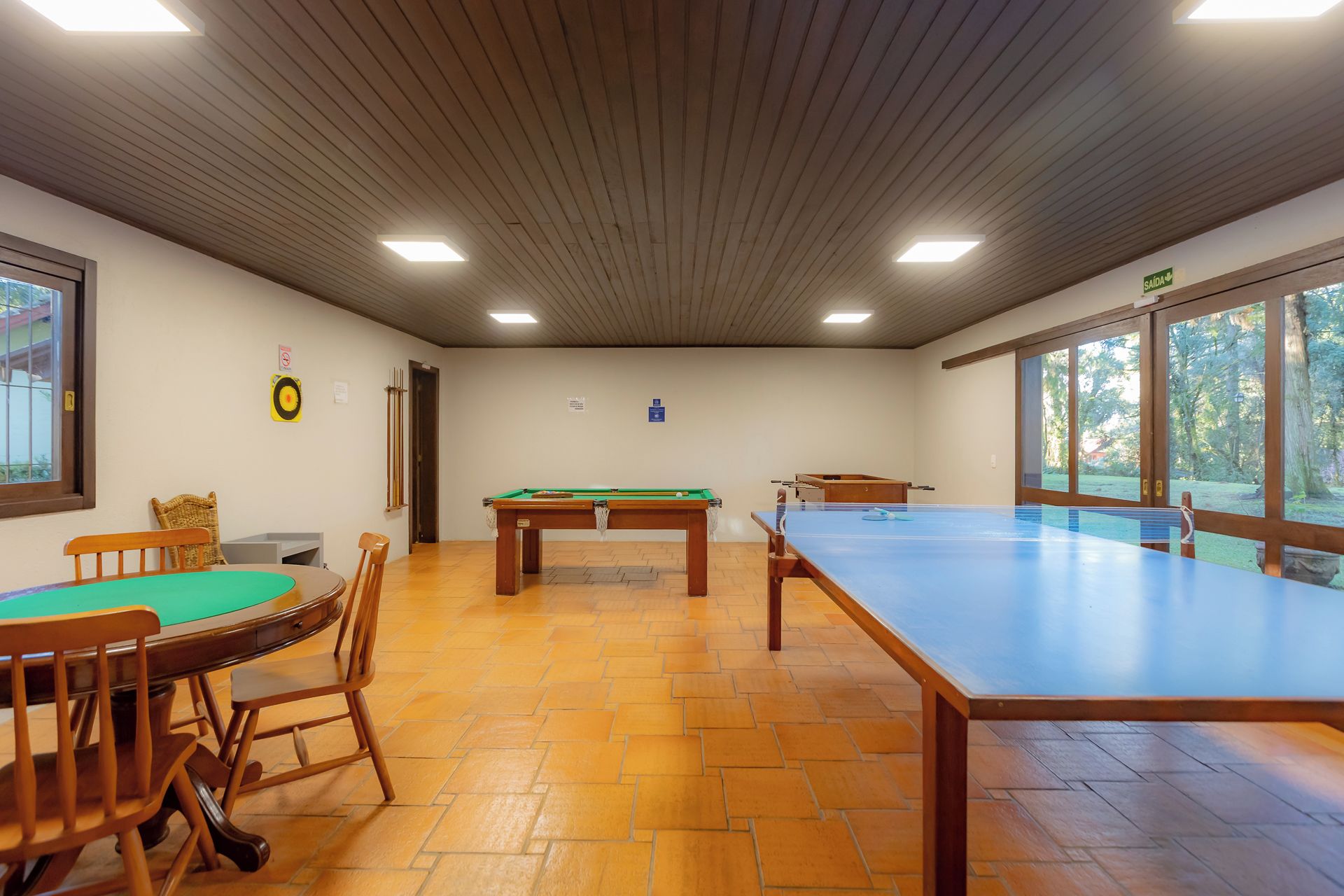 Um quarto com mesa de bilhar, mesa de sinuca e mesa de pingue-pongue.