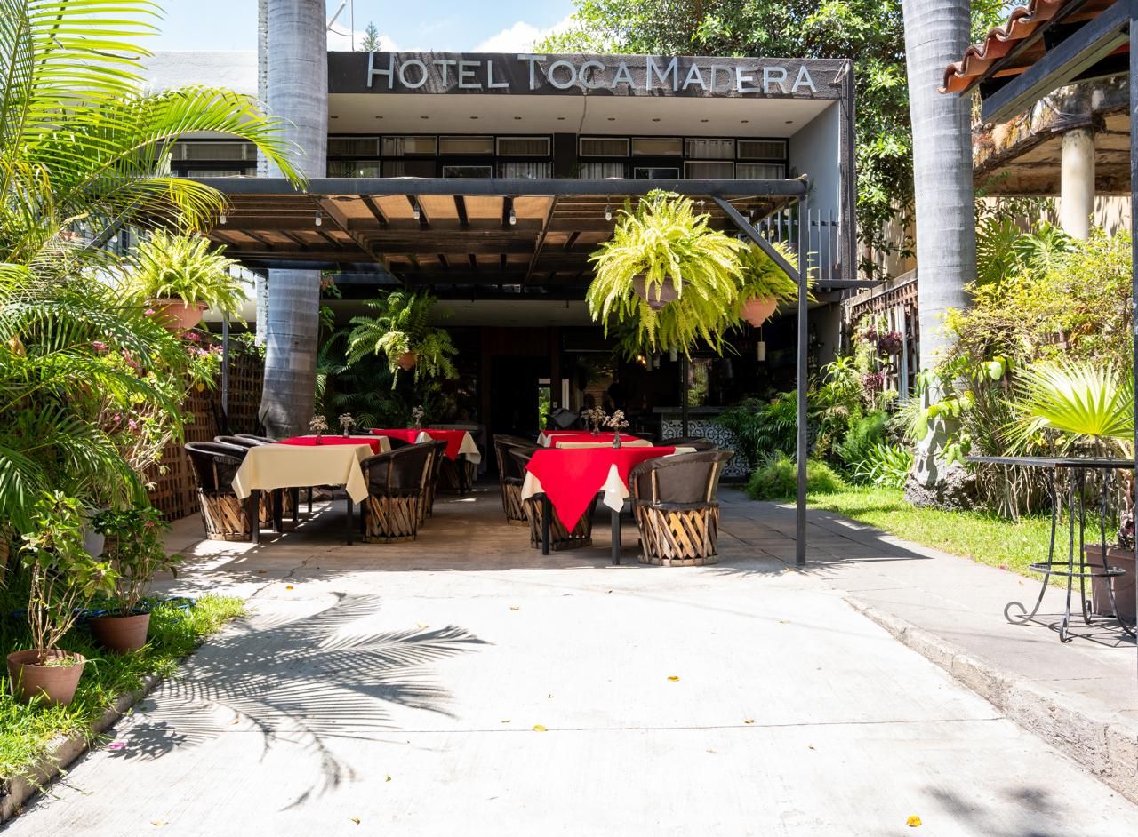 Entrada de hotel com área de estar ao ar livre e espaço coberto.