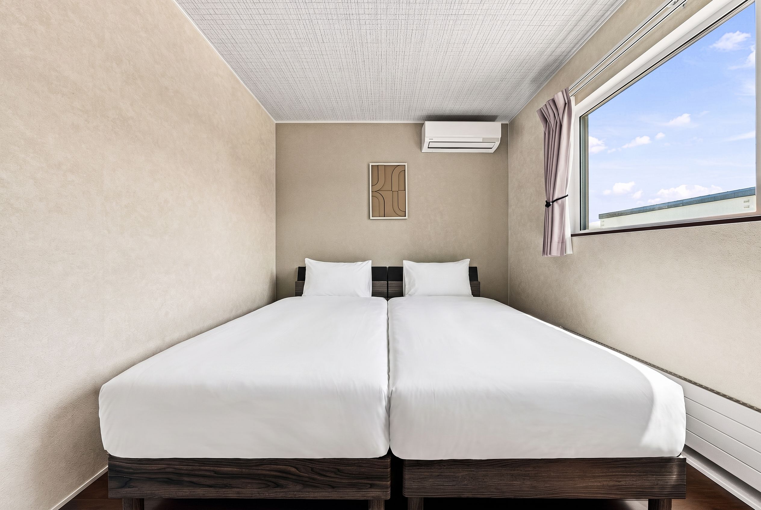 Quarto com cama, janela e ar condicionado.