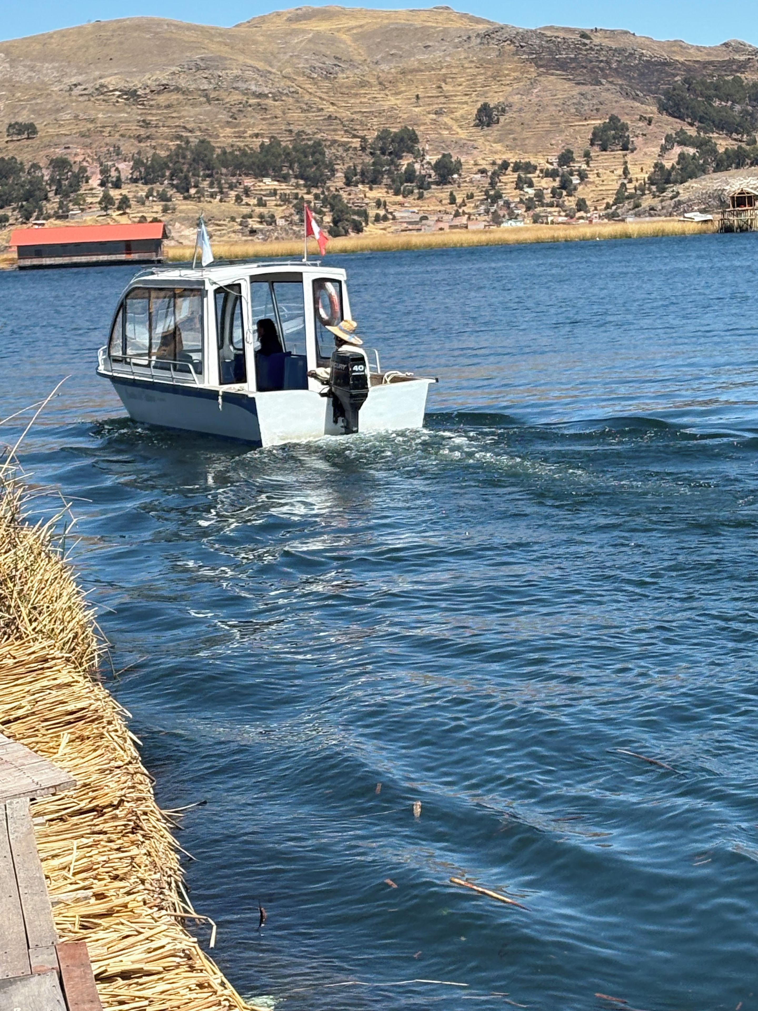 Um barco em um lago calmo, com montanhas ao fundo.