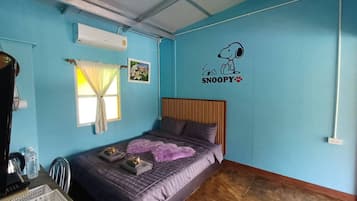 Quarto com cama, escrivaninha, cadeira, ar-condicionado, janela com cortinas e um adesivo de parede.