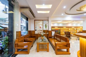 Decoração moderna com bancos de madeira, mesa de vidro e espaço para lanches.