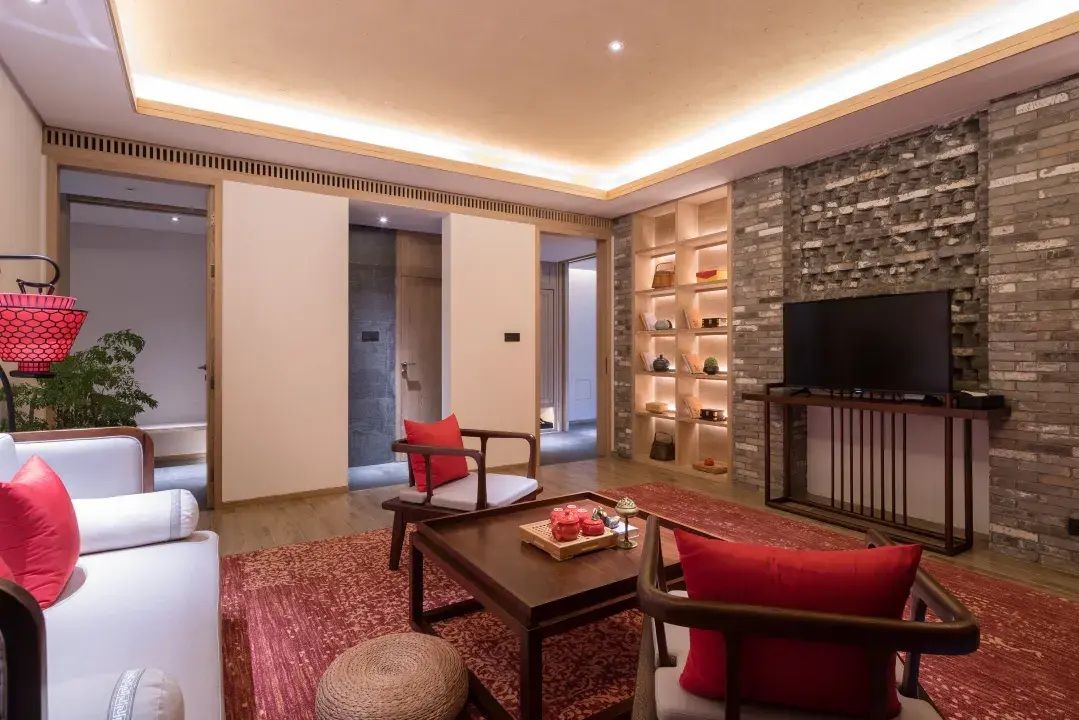 Uma sala de estar moderna com lareira, área de estar e painel de entretenimento.