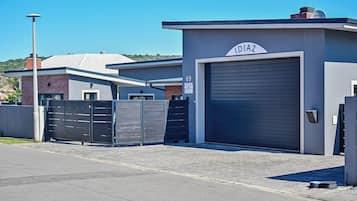 Um edifício moderno com uma porta de garagem identificada com 'DIAZ' e uma entrada com portão.