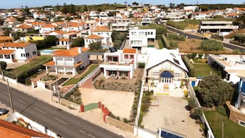 Área residencial com várias casas, uma rua principal e um amplo espaço aberto em primeiro plano.