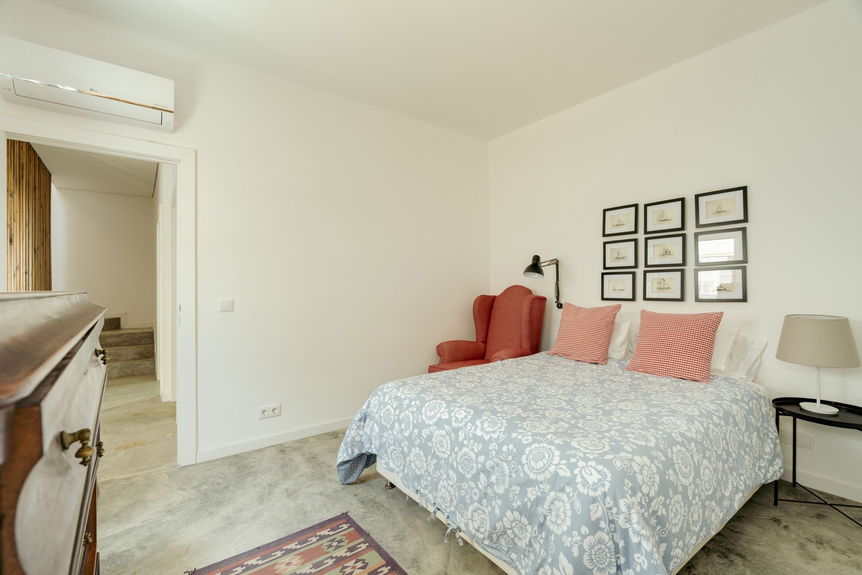 Quarto com cama, cadeira, escrivaninha e abajur.