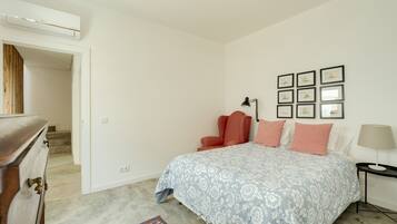 Quarto com cama, cadeira, escrivaninha e abajur.