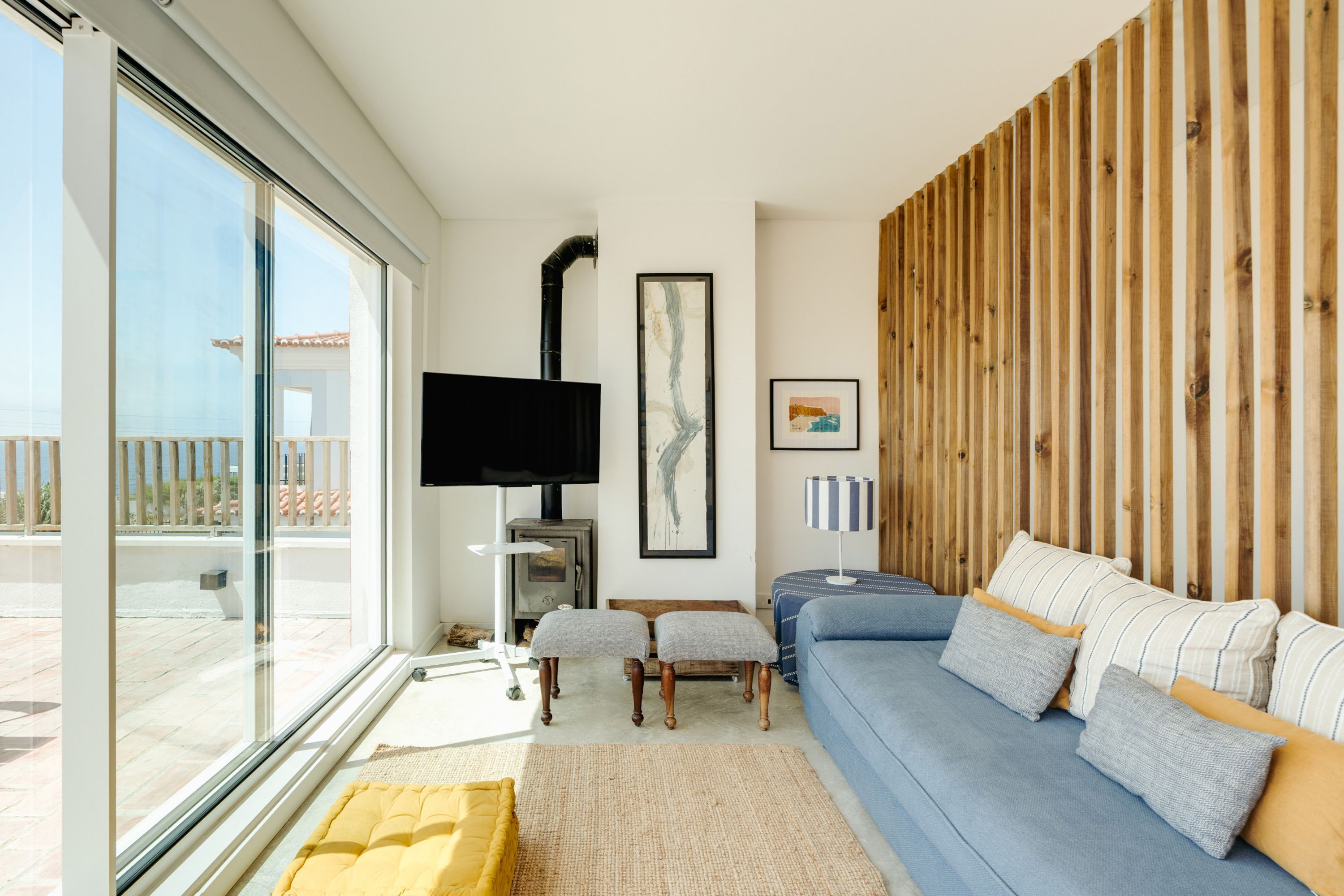 Uma sala de estar moderna com uma janela grande, lareira, sofá e televisão.