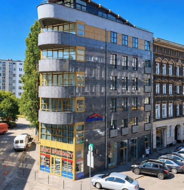 Edifício de vários andares com design moderno, apresentando um espaço comercial no térreo com vitrine aparente.