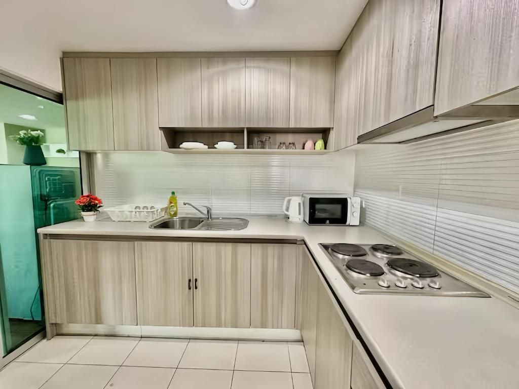 Cozinha compacta com micro-ondas, pia e fogão.
