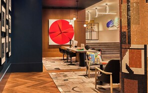 Decoração moderna com uma grande obra de arte circular vermelha, piso de madeira e móveis contemporâneos.