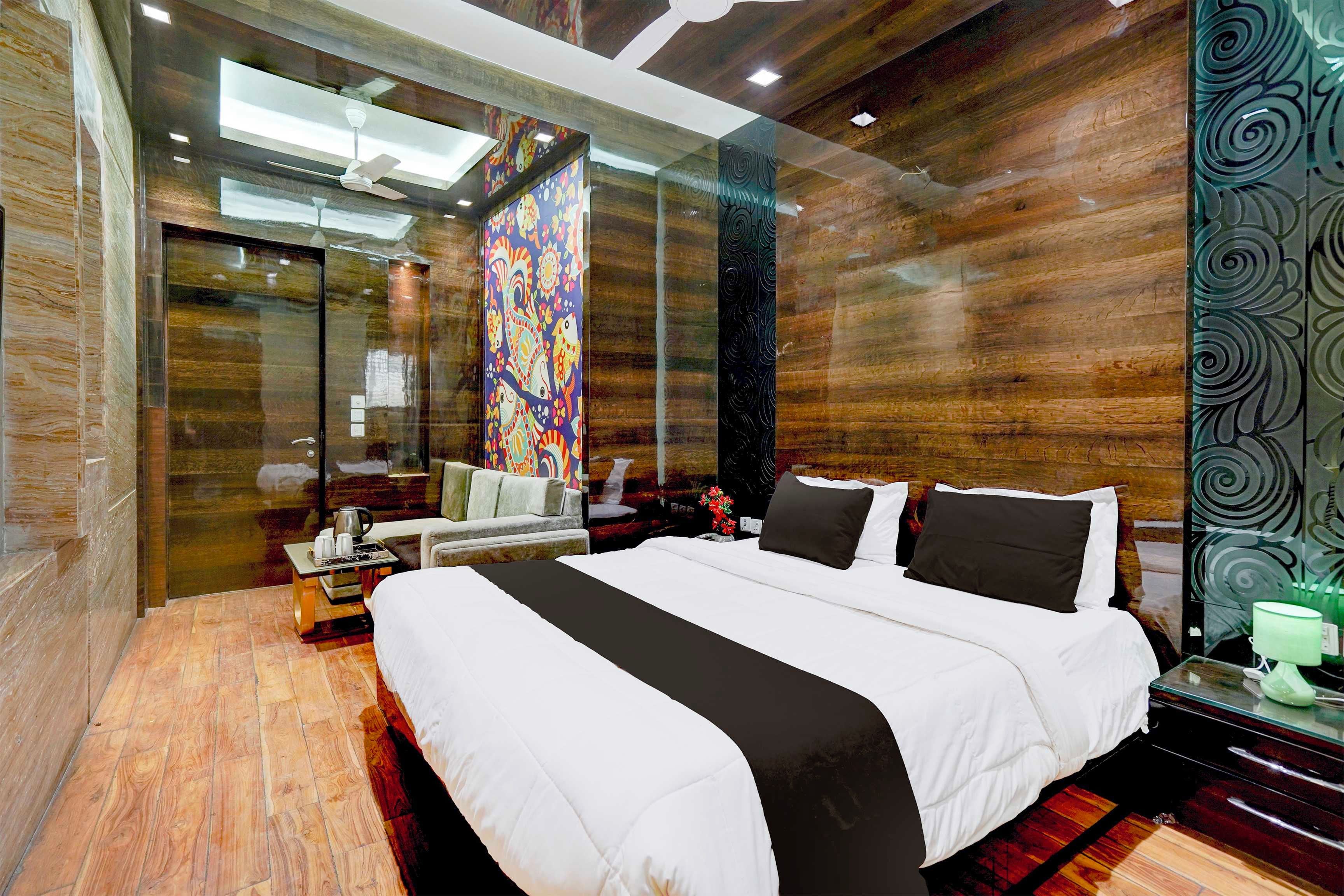 Quarto de hotel moderno com uma cama grande, uma mesa de escritório e uma área de estar.