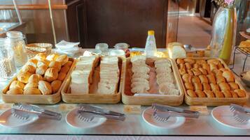Buffet com diversas opções de pão e utensílios.