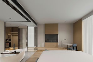Quarto de hotel moderno com cama grande, banheira embutida, televisão de tela plana e área de estar com mesa e cadeira.