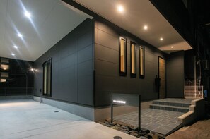 Fachada moderna de um edifício com telhado plano, grandes janelas e uma placa com a inscrição 'VILLA SASEBO Stad'.