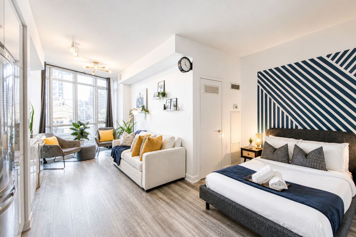 Quarto moderno com uma cama grande, um sofá e uma área de refeições.