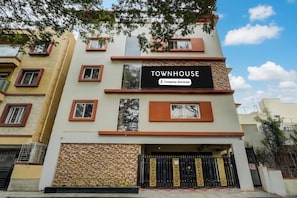 Um edifício de vários andares com uma placa indicando 'TOWNHOUSE Company-Serviced'.