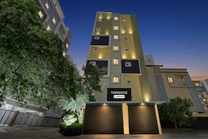 Um edifício residencial de vários andares com uma placa indicando 'TOWNHOUSE & Company Senecot'.