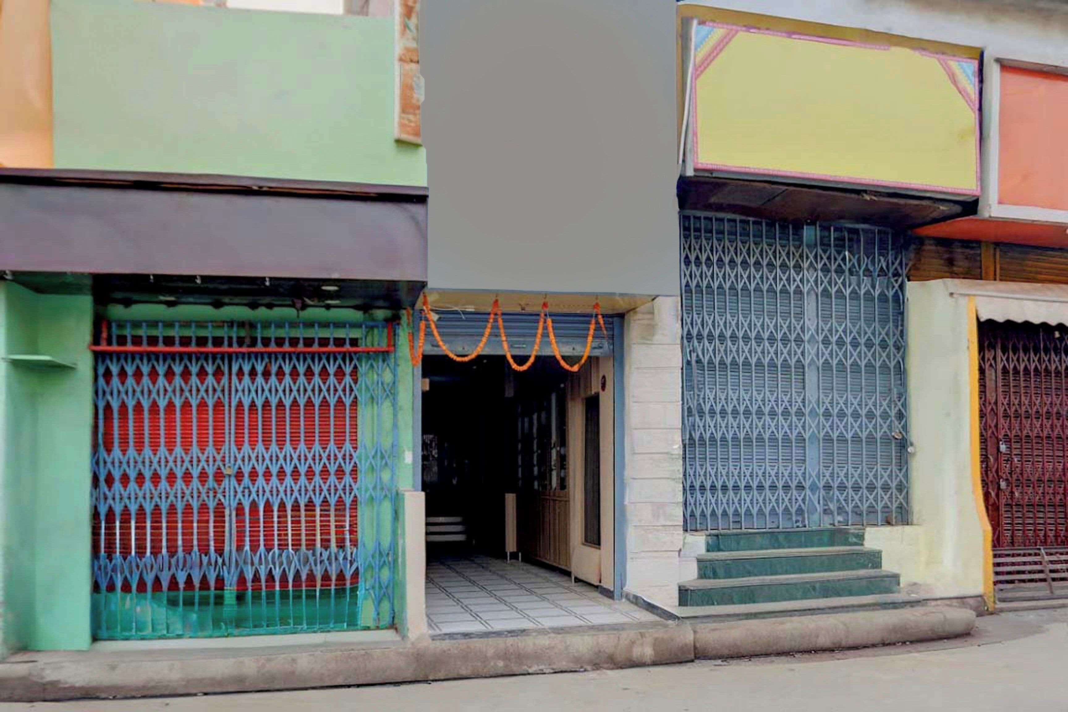 Fileira de edifícios com portões de metal e uma escadaria que leva à entrada.