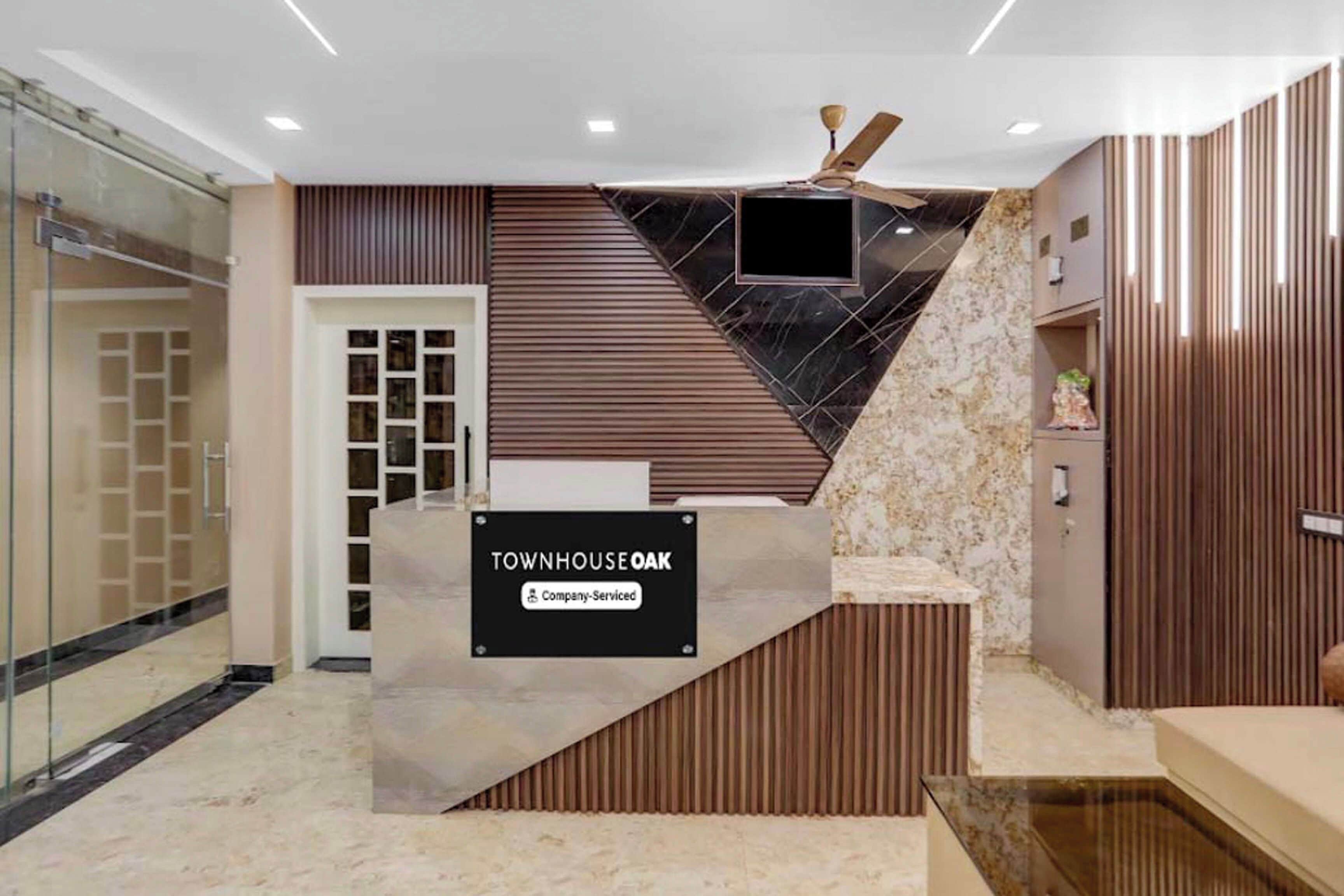 Uma mesa de recepção com uma placa que diz 'TOWNHOUSE OAK' e 'Serviços para Empresas'.