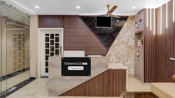 Uma mesa de recepção com uma placa que diz 'TOWNHOUSE OAK' e 'Serviços para Empresas'.