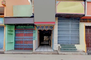 Um edifício com entrada de loja fechada, escadas que levam à entrada e um portão de metal.