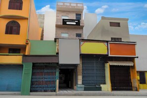 Uma fileira de edifícios altos com diversos estabelecimentos comerciais, incluindo uma placa com 'TOWNHOUSE OAK'.