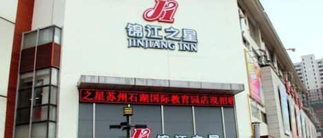 Um edifício com a sinalização do Jintang Inn, exibindo um logotipo destacado e caracteres chineses.