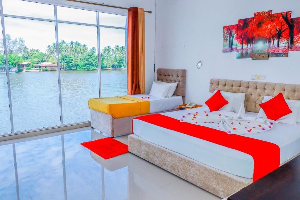 Quarto de hotel com uma janela grande, uma cama, um sofá e um quadro na parede.