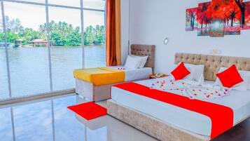 Quarto de hotel com uma janela grande, uma cama, um sofá e um quadro na parede.