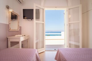 Quarto com duas camas, televisão e vista para o mar.