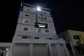 Um edifício de vários andares com uma placa indicando que se trata de uma casa geminada com serviços para empresas.