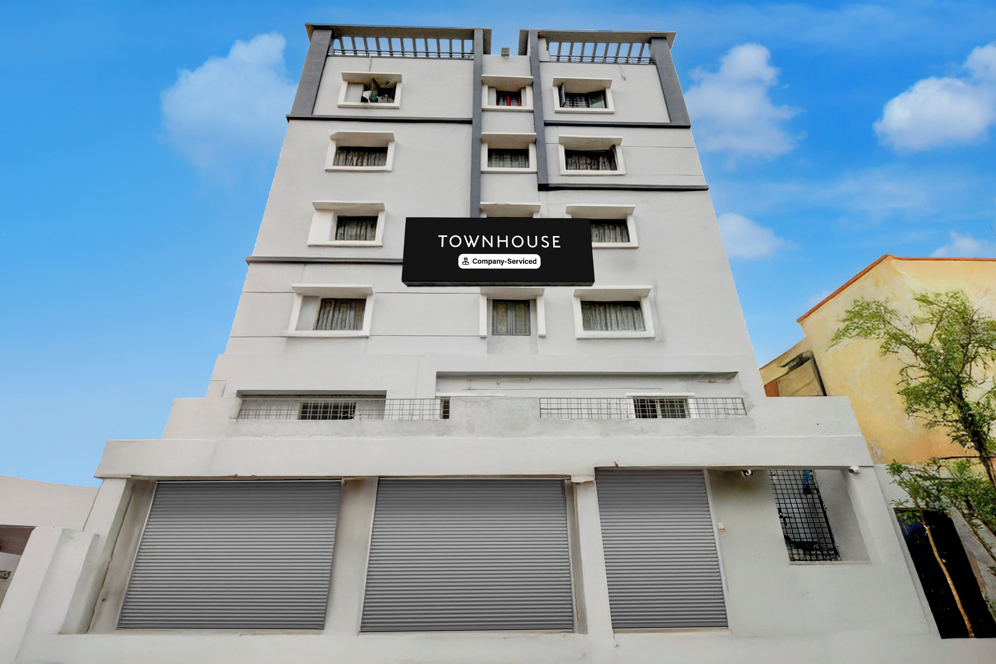 Um edifício de vários andares com uma placa indicando 'TOWNHOUSE Company Serviced'.