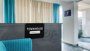 Uma área de recepção com uma placa indicando 'TOWNHOUSE Company-Serviced'.