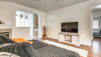 Sala de estar com lareira, televisão e um tapete grande.