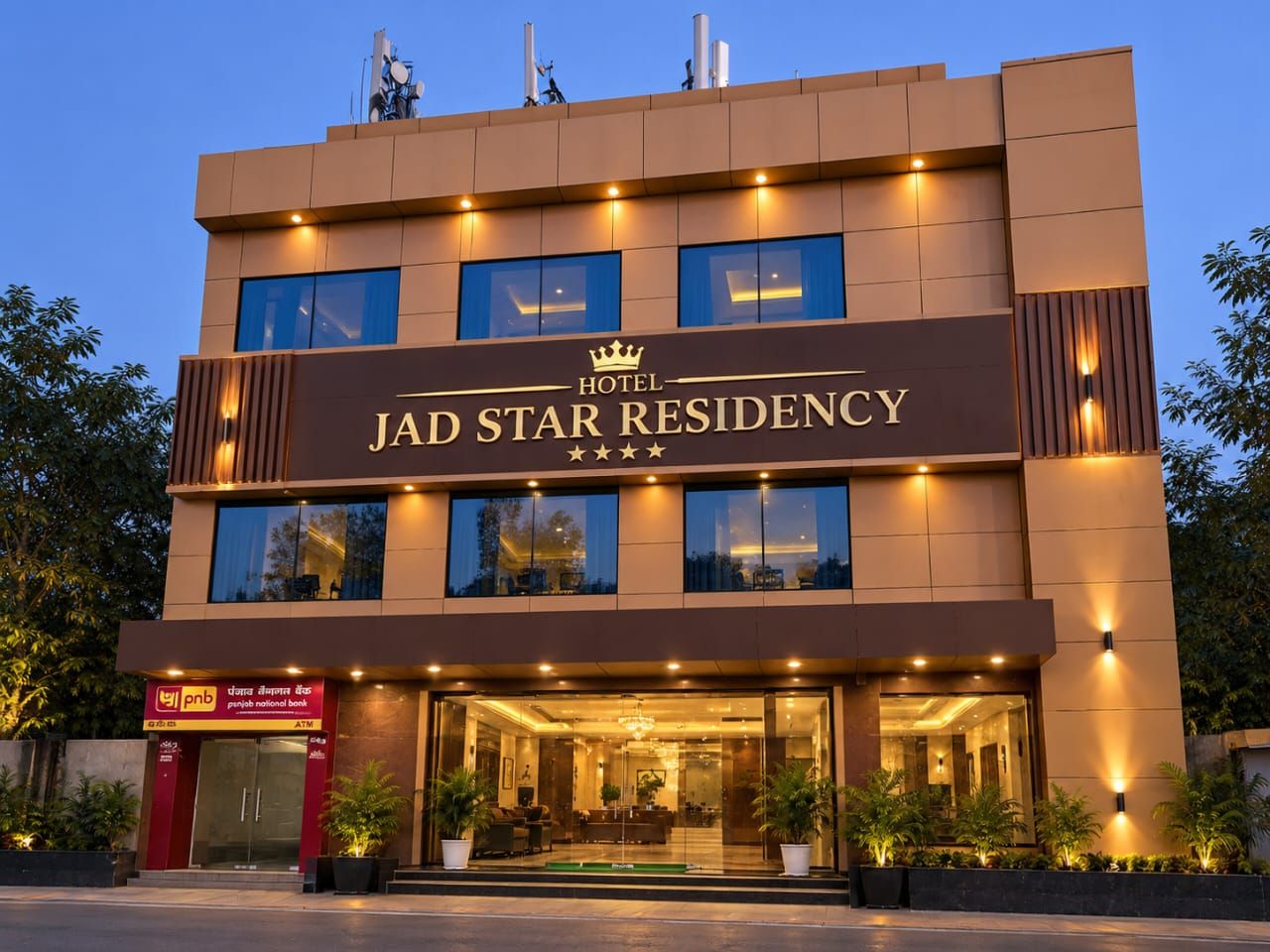 Um hotel de vários andares com uma placa chamativa indicando 'JAD STAR RESIDENCY' e uma entrada visível com área de recepção.
