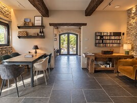 Um interior moderno com área de refeições, cozinha e estante de livros.
