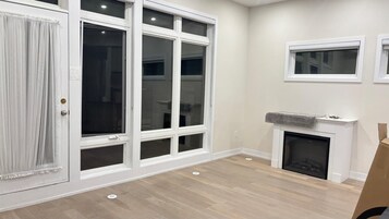 Quarto com porta de vidro deslizante, lareira e uma pequena janela.