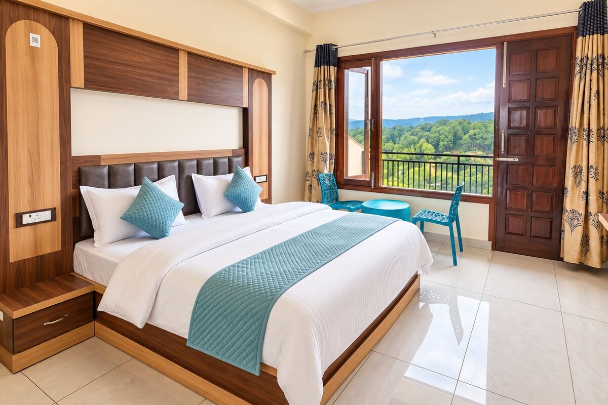 Quarto com cama, televisão, varanda com vista e janela com cortinas.