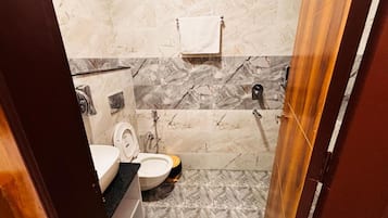 Casa de banho com sanita, lavatório e zona de duche.