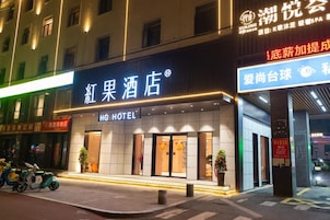 Um hotel com uma placa indicando 'HG HOTEL' e outra placa para 'XUNJING SPA'.