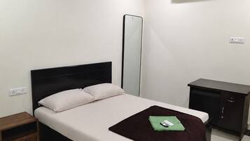 Quarto com cama, mesa de cabeceira e ar condicionado.