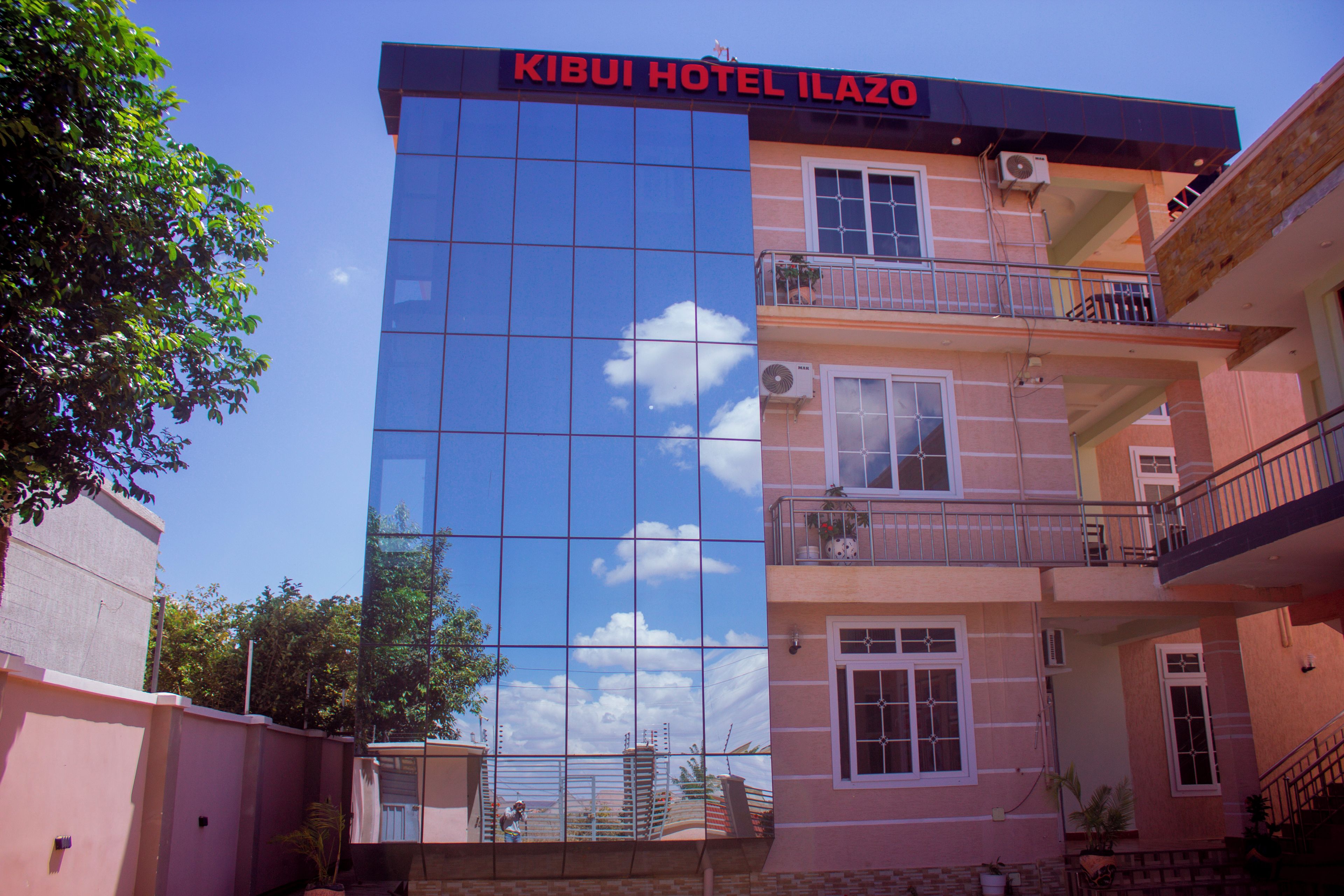 Hotel com fachada de vidro refletivo, varandas e céu claro.