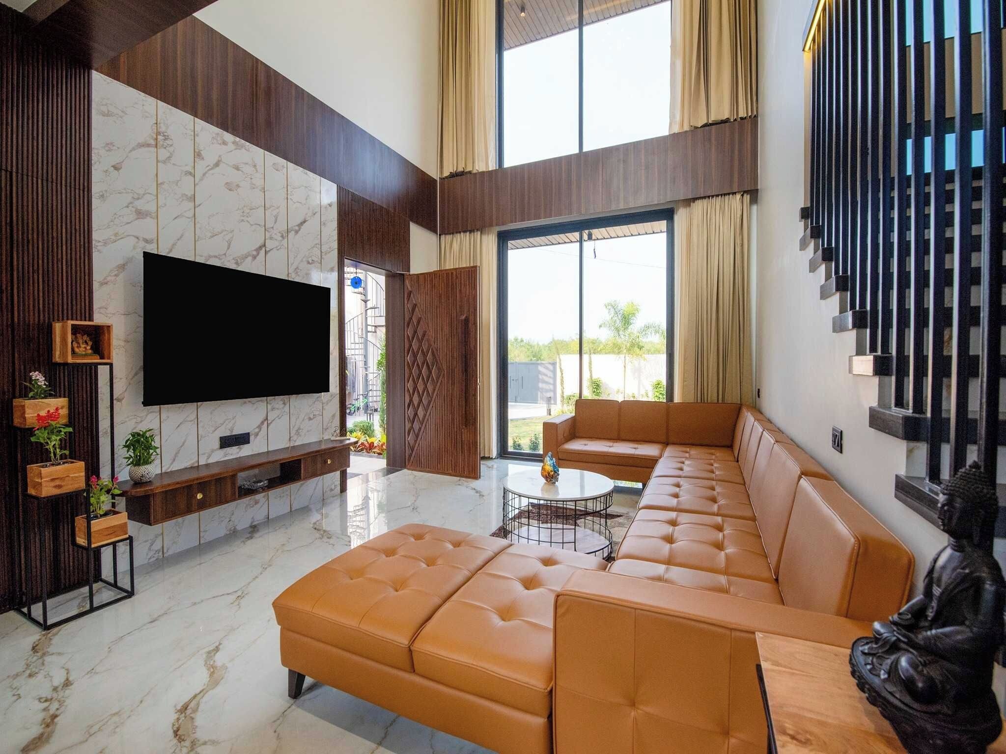 Uma sala de estar moderna com uma grande televisão de tela plana, um sofá de couro, uma mesa de centro e uma estátua.